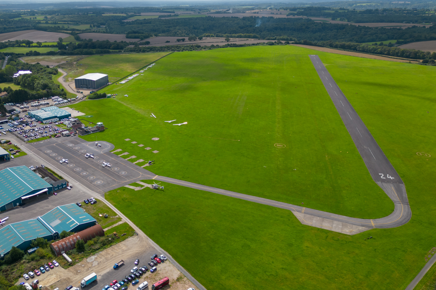 Airfield with aircraft, hangars, control tower and other buildings for ...